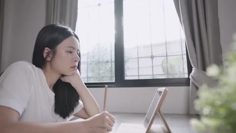 Asian bored girl writing on a paper book... | Stock Video | Pond5
