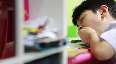 Asian boring boy doing homework at home | Stock Video | Pond5