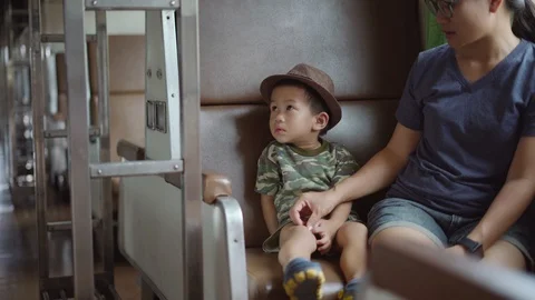 Asian boy is riding a train with his mot... | Stock Video | Pond5