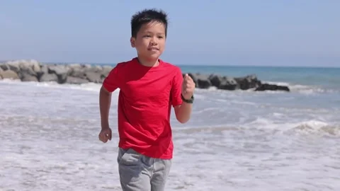 Asian boy running on the beach. Slow Mot... | Stock Video | Pond5