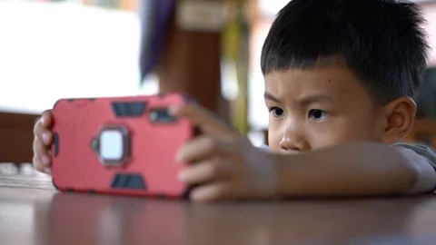 Asian boy using mobile phone for watchin... | Stock Video | Pond5