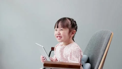 Asian child with fringe in hair sitting ... | Stock Video | Pond5