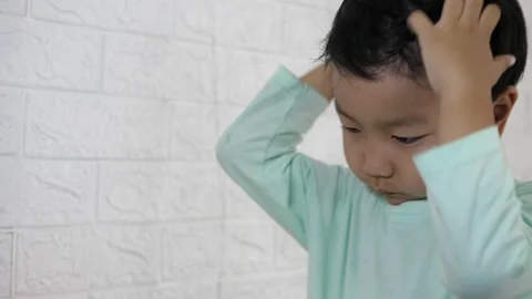 Asian cute child boy scratch head by han... | Stock Video | Pond5