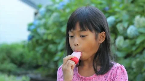 Asian Girl Eating A Popsicle | Stock Video | Pond5