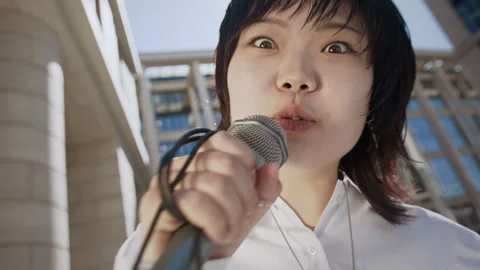 Asian Girl Singing in Microphone at Came... | Stock Video | Pond5
