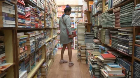 Asian girl walking between the rows of b... | Stock Video | Pond5