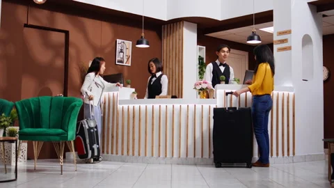 Asian guests approach reception to ask a... | Stock Video | Pond5