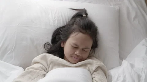 Asian little girl sleeping in bed and wa... | Stock Video | Pond5