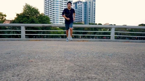Asian runner run in park and jump across... | Stock Video | Pond5
