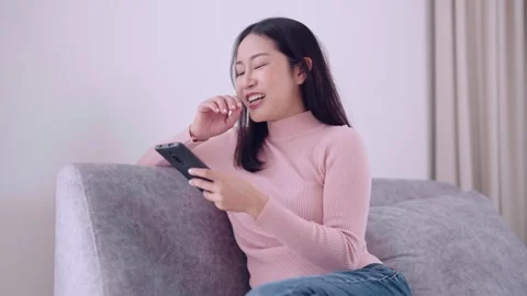 Asian woman happily using her phone for ... | Stock Video | Pond5
