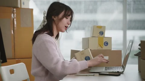 Asian woman packing products in boxes an... | Stock Video | Pond5