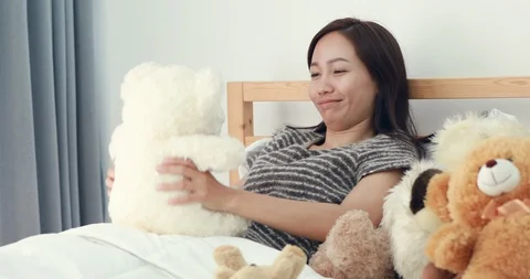 Asian woman with teddy bear on the bed. | Stock Video | Pond5