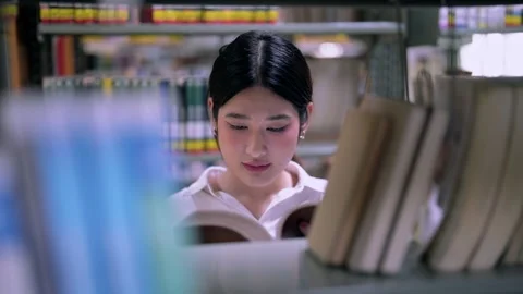 Asian women Students at rows of bookshel... | Stock Video | Pond5