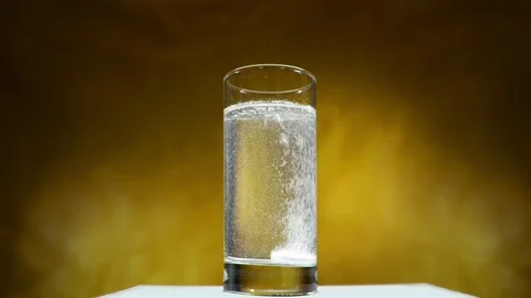 Aspirin tablet dissolves in water on a y... | Stock Video | Pond5
