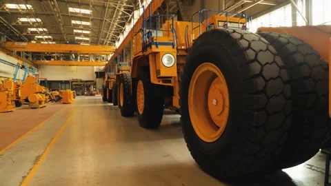 An assembly line of large dump trucks. A... | Stock Video | Pond5