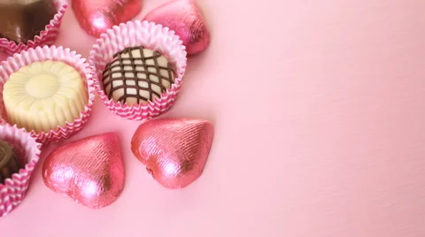 Assorted chocolates on pink background. | Stock Video | Pond5