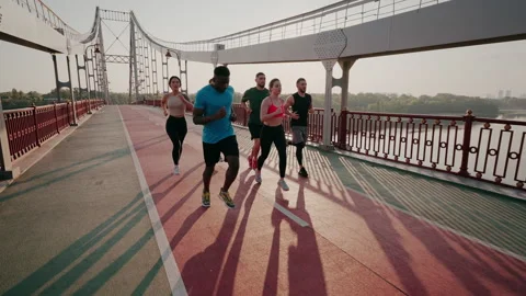 Athletes run on red bicycle path on mode... | Stock Video | Pond5
