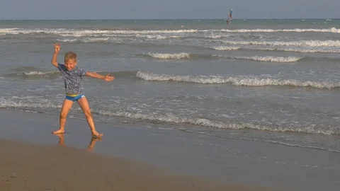athletic boy on the beach in jump on the... | Stock Video | Pond5