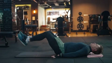 Athletic man doing leg raises lying on y... | Stock Video | Pond5