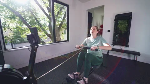 Athletic woman uses a rowing erg machine... | Stock Video | Pond5