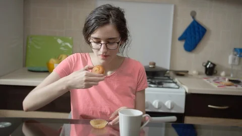 Attractive brunette girl eating a muffin... | Stock Video | Pond5