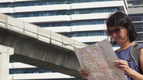 Attractive woman reading tourist map on ... | Stock Video | Pond5