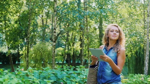 Attractive woman walking with a tablet i... | Stock Video | Pond5