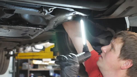 Auto mechanic inspecting bottom and susp... | Stock Video | Pond5