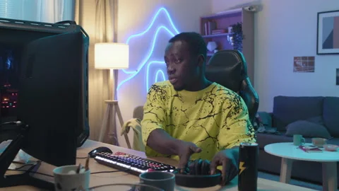 Avid Black Gamer Sitting Down to Play Vi... | Stock Video | Pond5