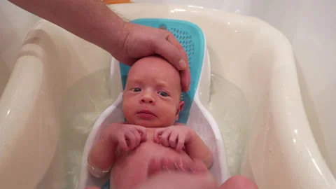 Baby boy bathes in a bath father bathing... | Stock Video | Pond5