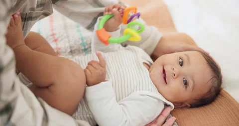 Baby child, parent and rattle on bed wit... | Stock Video | Pond5