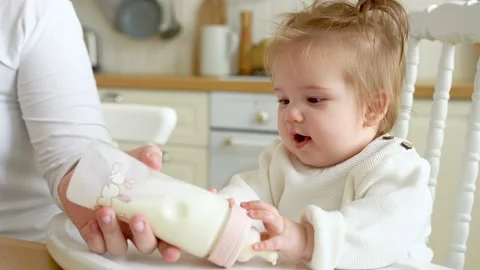 Baby girl drinks powered milk formula fr... | Stock Video | Pond5