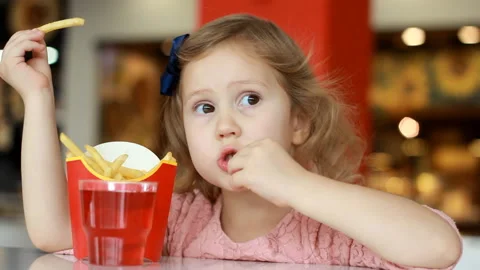 Baby girl eating fast food french fries ... | Stock Video | Pond5