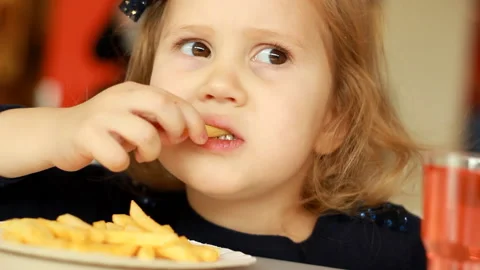 Baby girl eating fast food french fries ... | Stock Video | Pond5