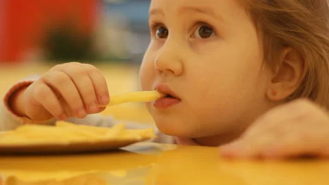 Baby girl eating fast food french fries ... | Stock Video | Pond5