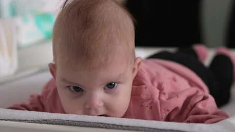 Baby girl lying in prone position on mat... | Stock Video | Pond5