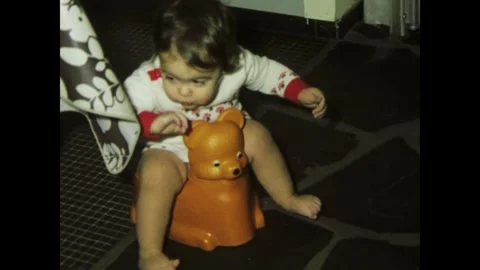 Baby girl is sitting on an orange potty ... | Stock Video | Pond5