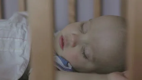 baby sleeping in crib face close-up with... | Stock Video | Pond5
