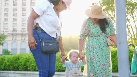 Baby taking first steps with mother and ... | Stock Video | Pond5