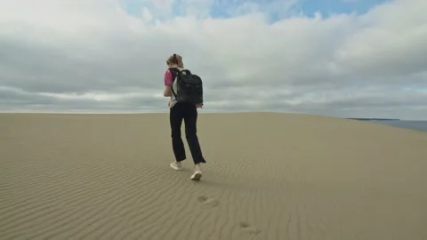 Back view of blonde girl walking on top ... | Stock Video | Pond5