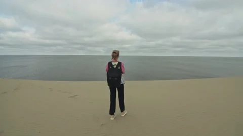 Back view of blonde girl walking on top ... | Stock Video | Pond5