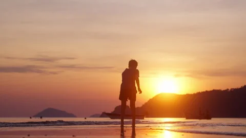 Back View Of Boy Jumping On Seashore | Stock Video | Pond5