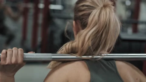 Back view of caucasian woman lifting bar... | Stock Video | Pond5