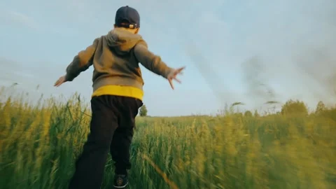Back view of a child running on the gras... | Stock Video | Pond5