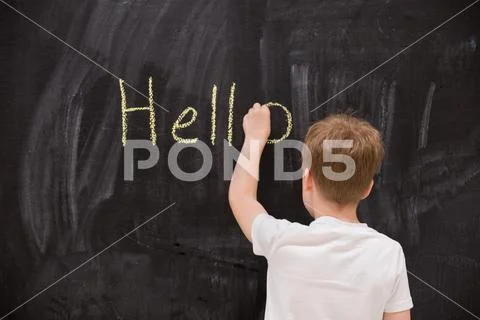 Photograph: Back view on cute kid boy writing Hello word with chalk on ...