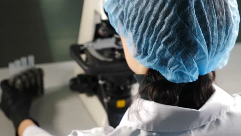 Back view of female scientist using micr... | Stock Video | Pond5