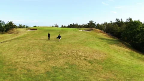 Back view of golfers walking on slope of... | Stock Video | Pond5