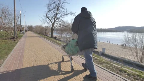 Back view of homeless man pushing shoppi... | Stock Video | Pond5