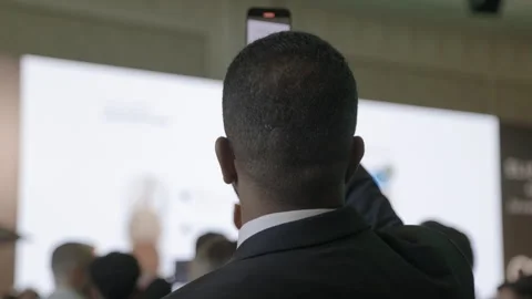 Back View of Individual Filming the Meet... | Stock Video | Pond5