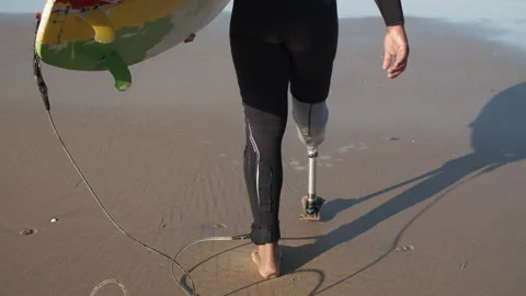 Back view of man with bionic leg going t... | Stock Video | Pond5